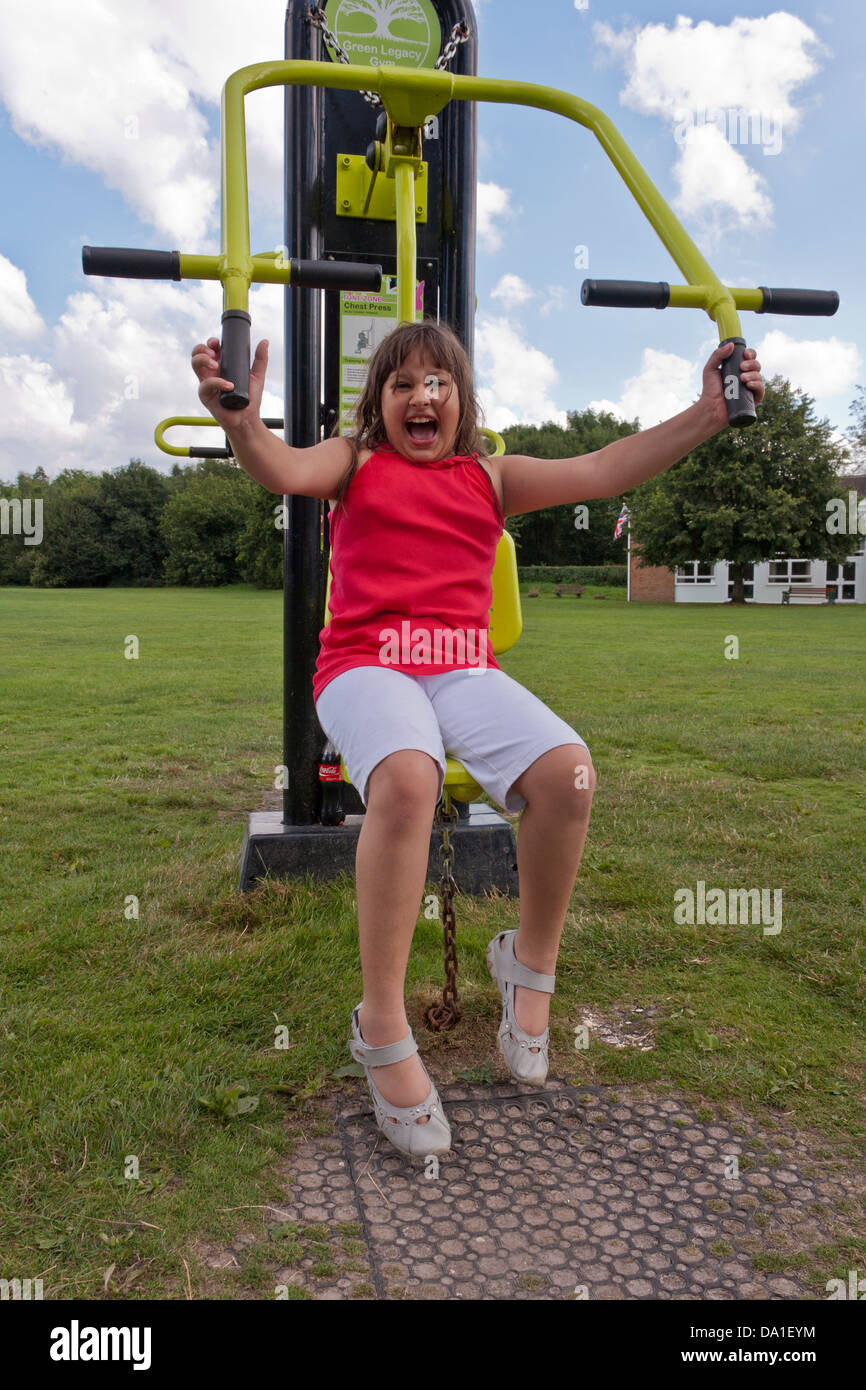 Child exercising at an outdoor gymnasium in a public park in southern ...