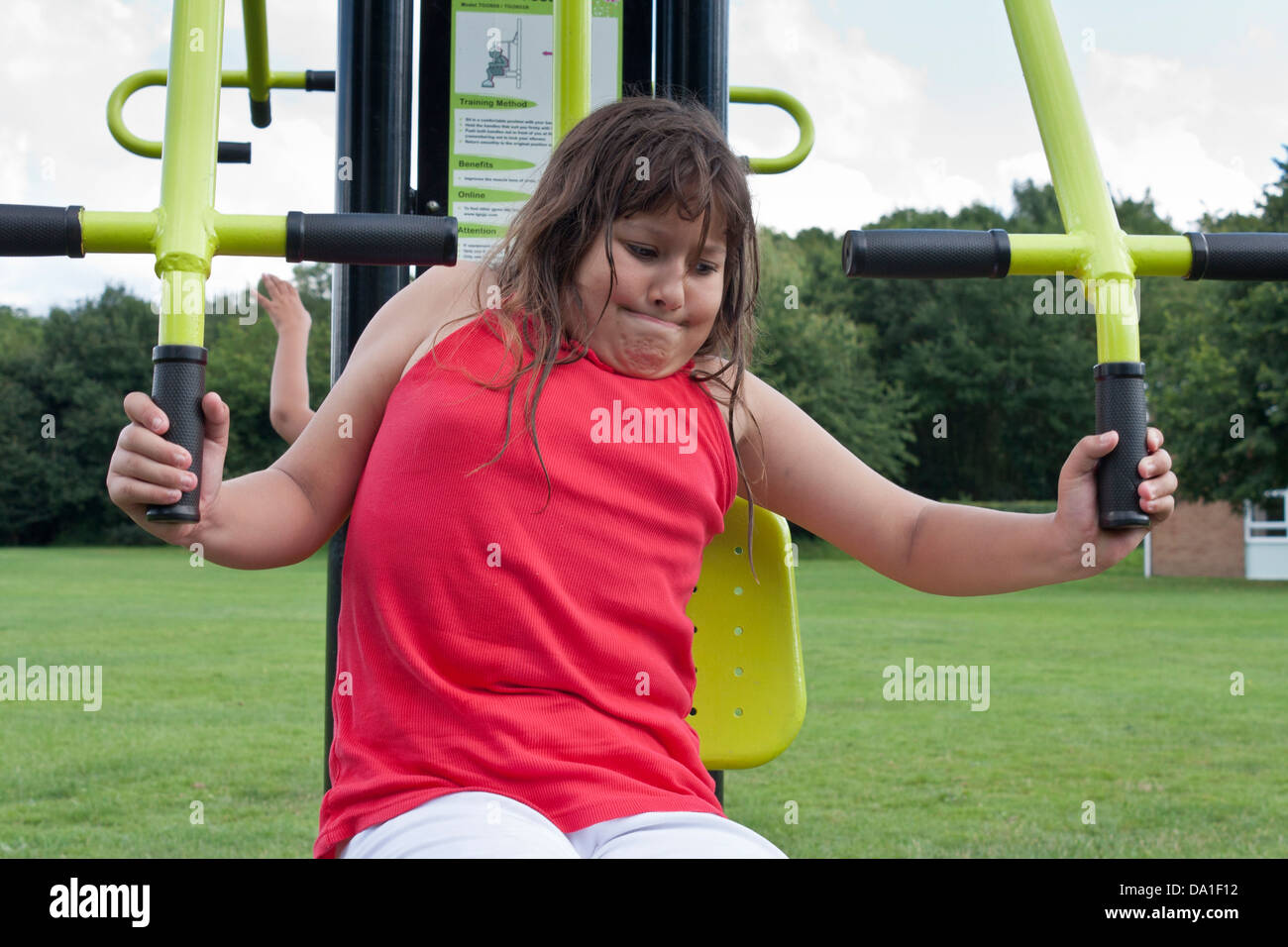 Children exercising at an outdoor gymnasium in a public park in ...