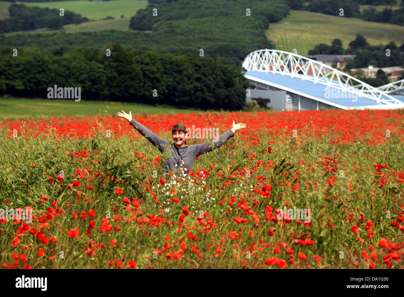 A young woman amongs fields of poppies and wild flowers just north of ...