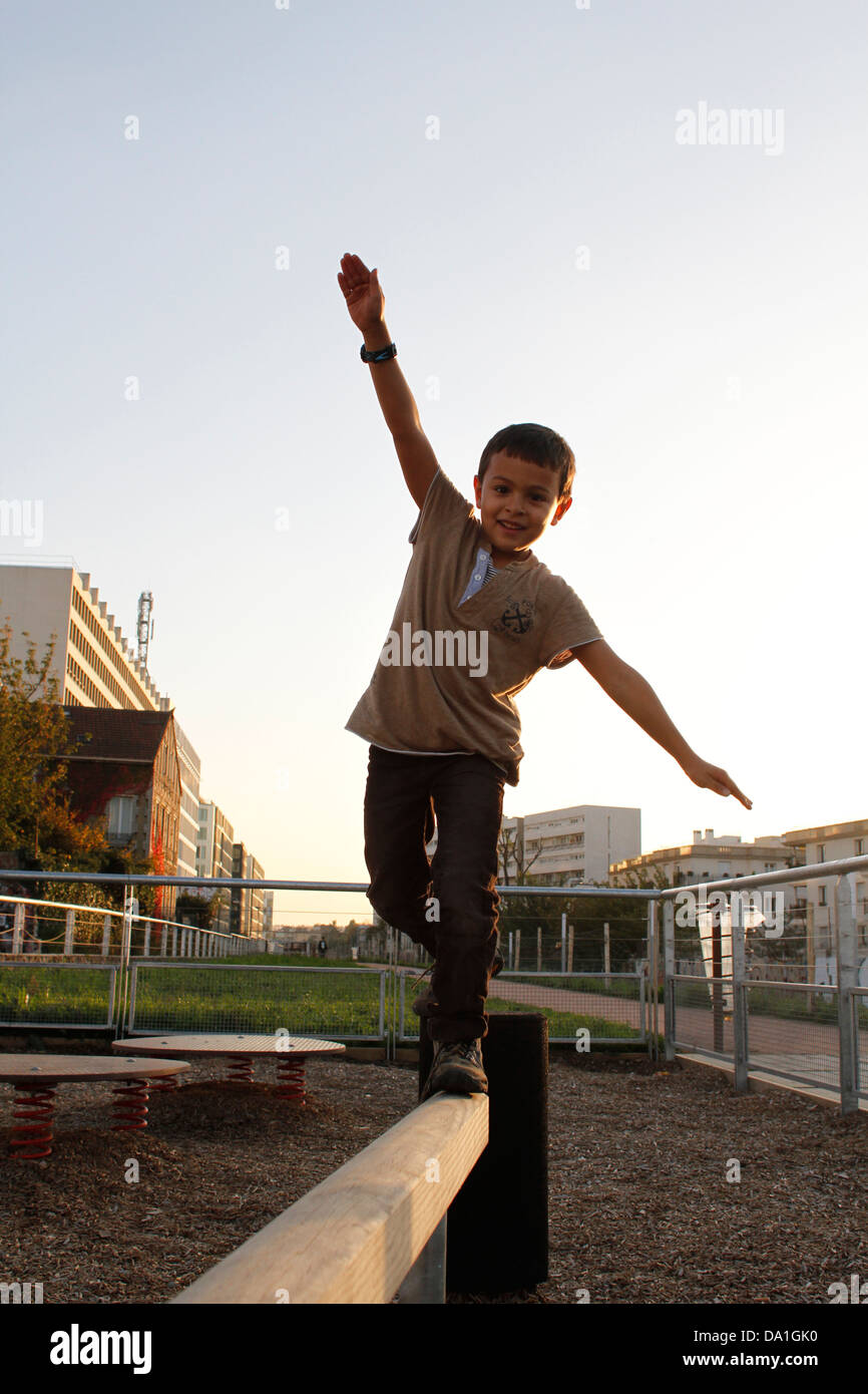 Boy walking on a beam Stock Photo - Alamy