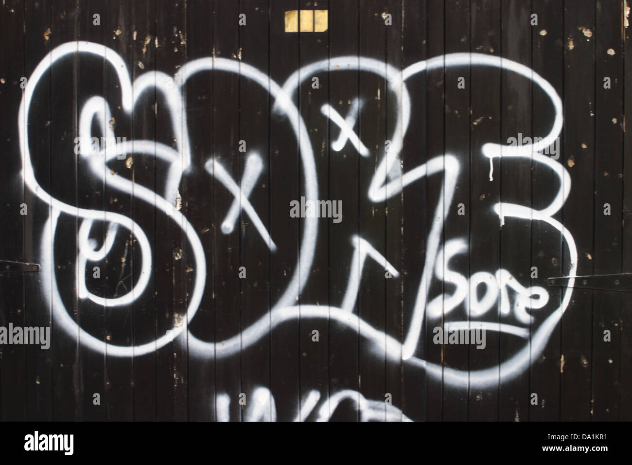 Black Wooden Back Gate with spray painted grafitti, graffiti is white ...