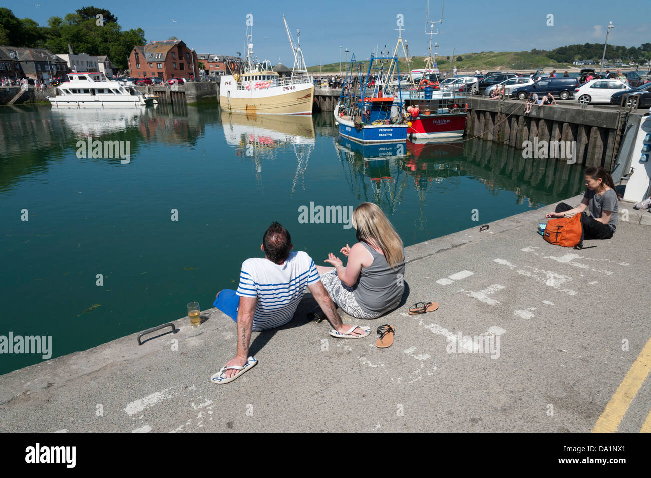 people sitting on the quay at Padstow Cornwall UK on a sunny summer day ...
