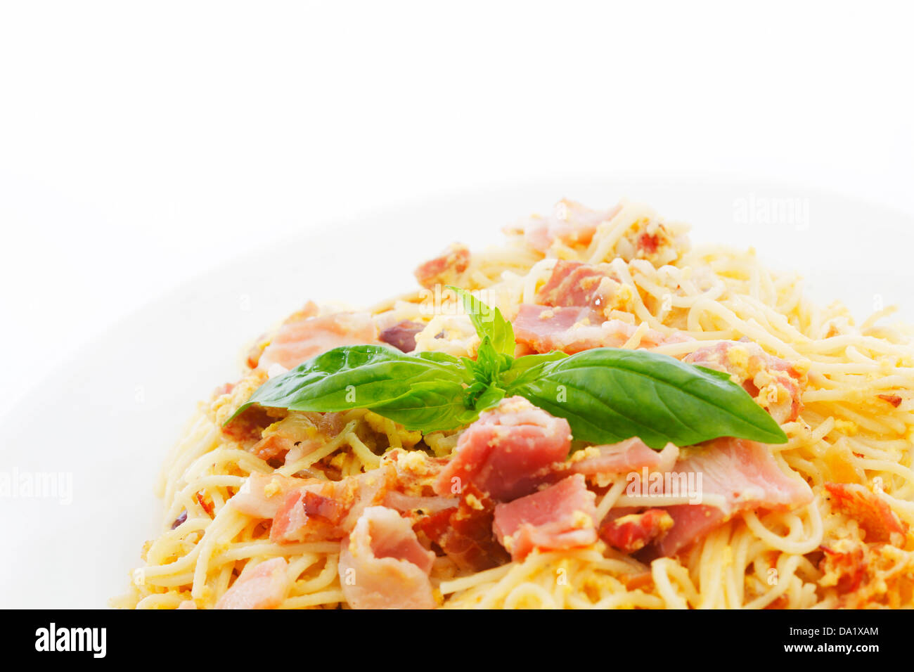 Spaghetti carbonara with fried bacon and basil isolated on white Stock ...