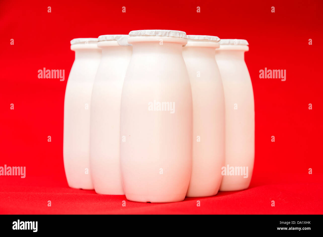 milk cans on a red background Stock Photo - Alamy