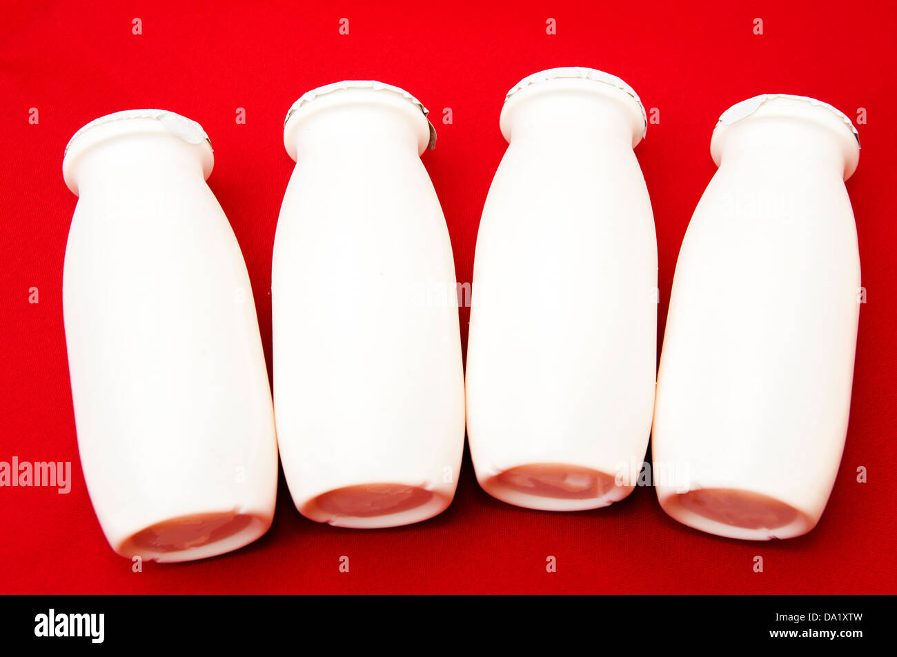 milk cans on a red background Stock Photo - Alamy
