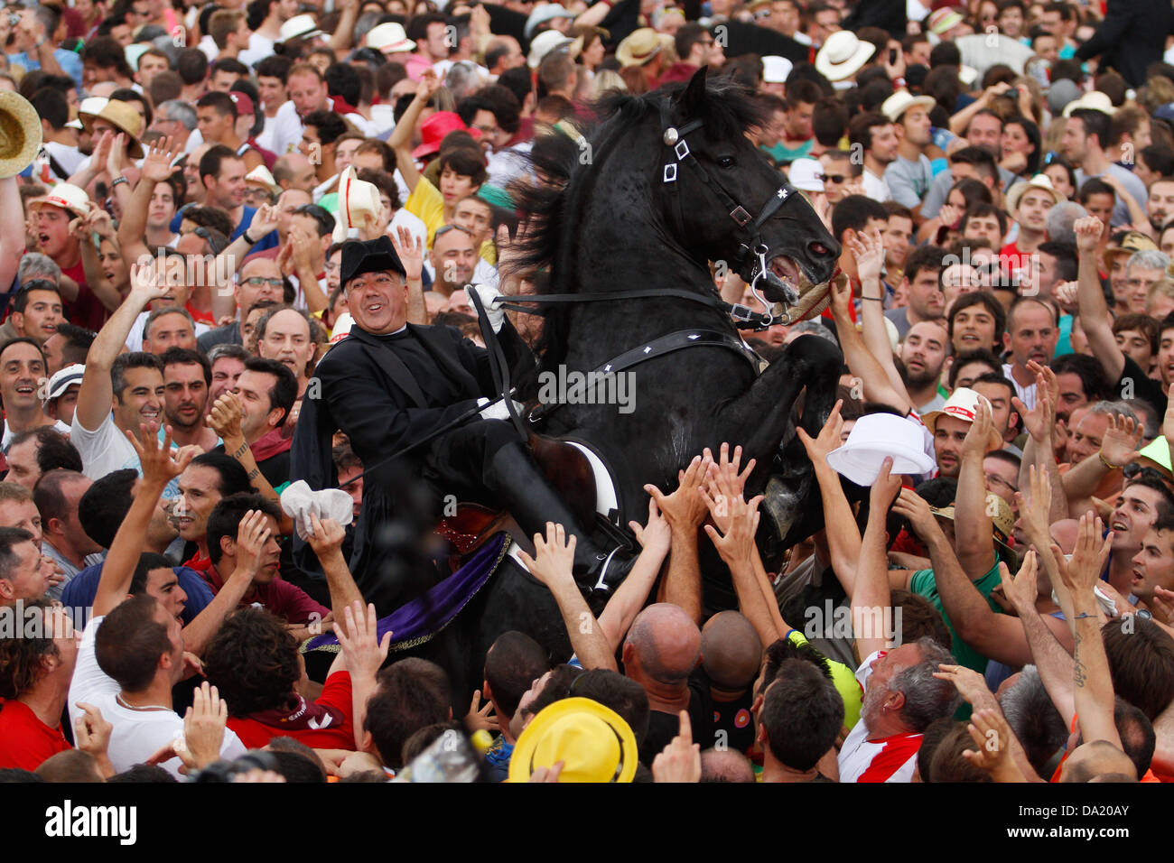 A rider rears up on his horse while surrounded by a cheering crowd ...
