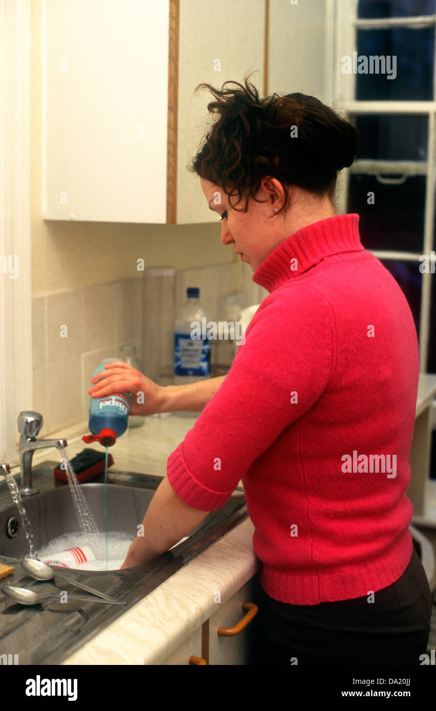 Teenage girl washing up at home, UK Stock Photo - Alamy