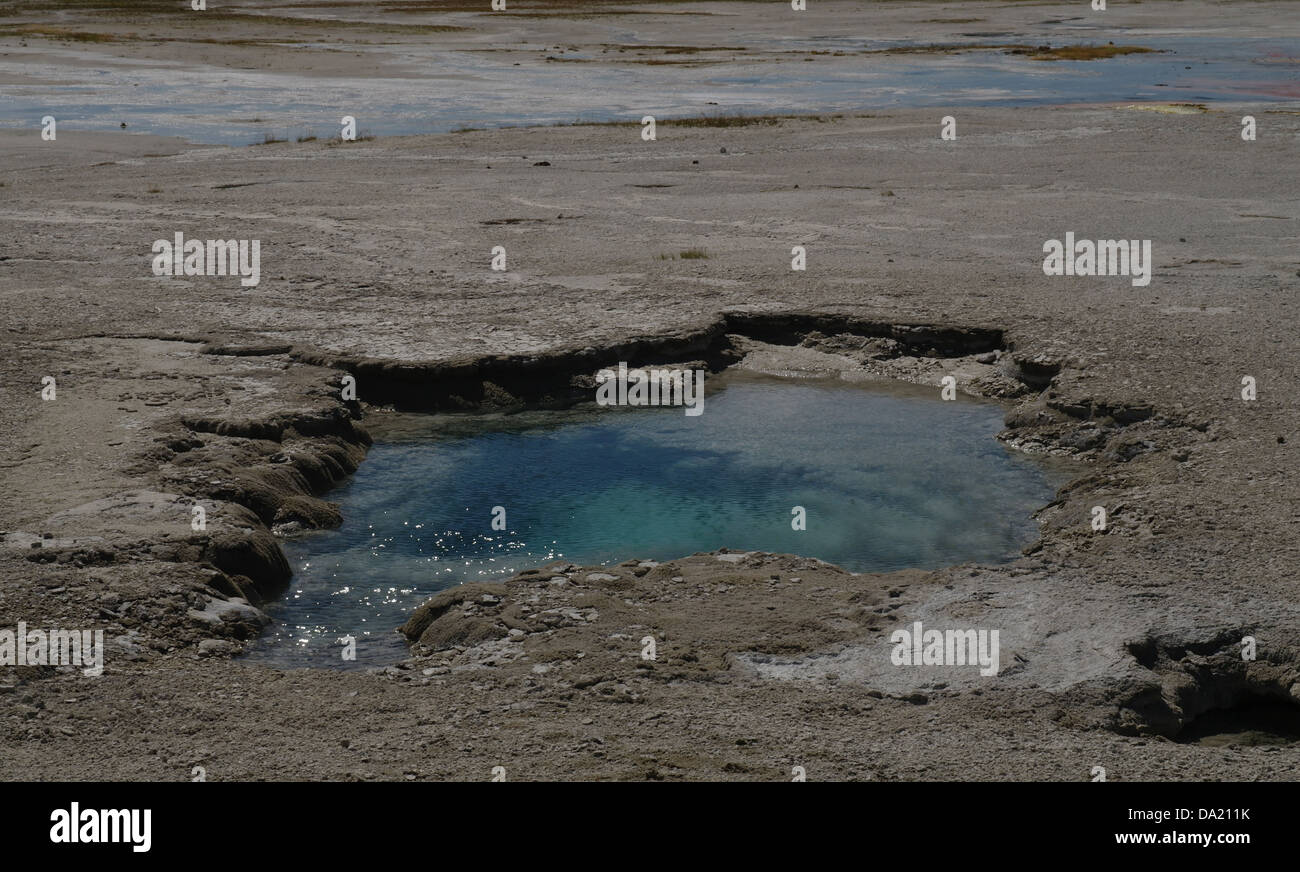 Clear blue glistening water Jelly Spring, with overhanging geyserite ...