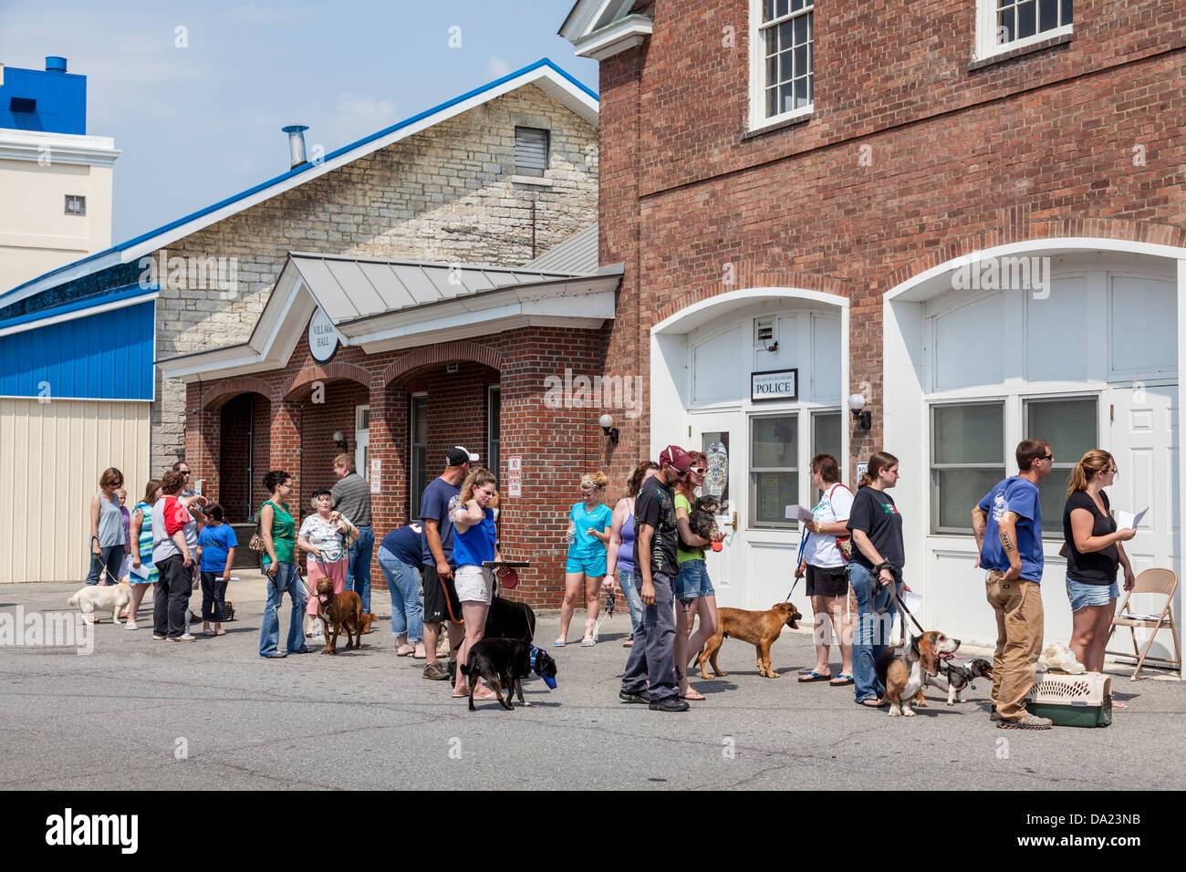 Pet owners queue up with their dogs for free rabies vaccines given by ...