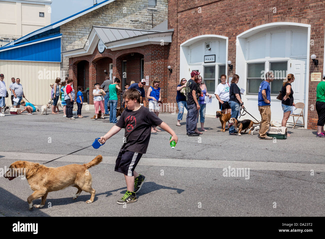 Pet owners queue up with their dogs for free rabies vaccines given by ...