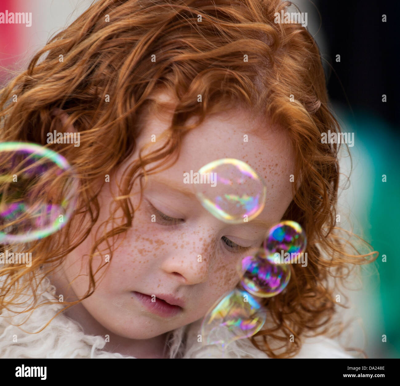 Young happy ginger haired girl playing with bubbles, Preston, UK Stock ...