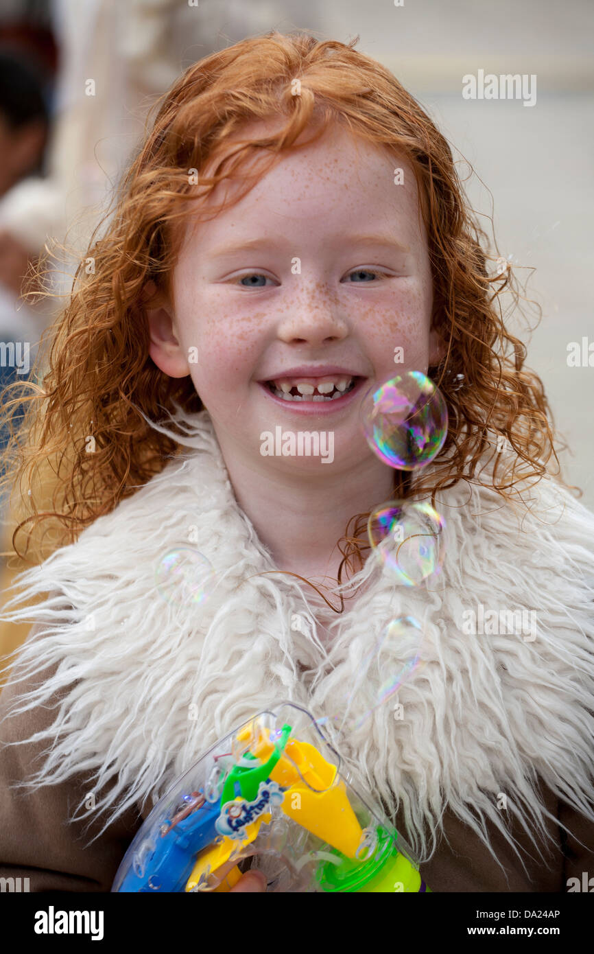 Young happy ginger haired girl playing with bubbles, Southport UK Stock ...