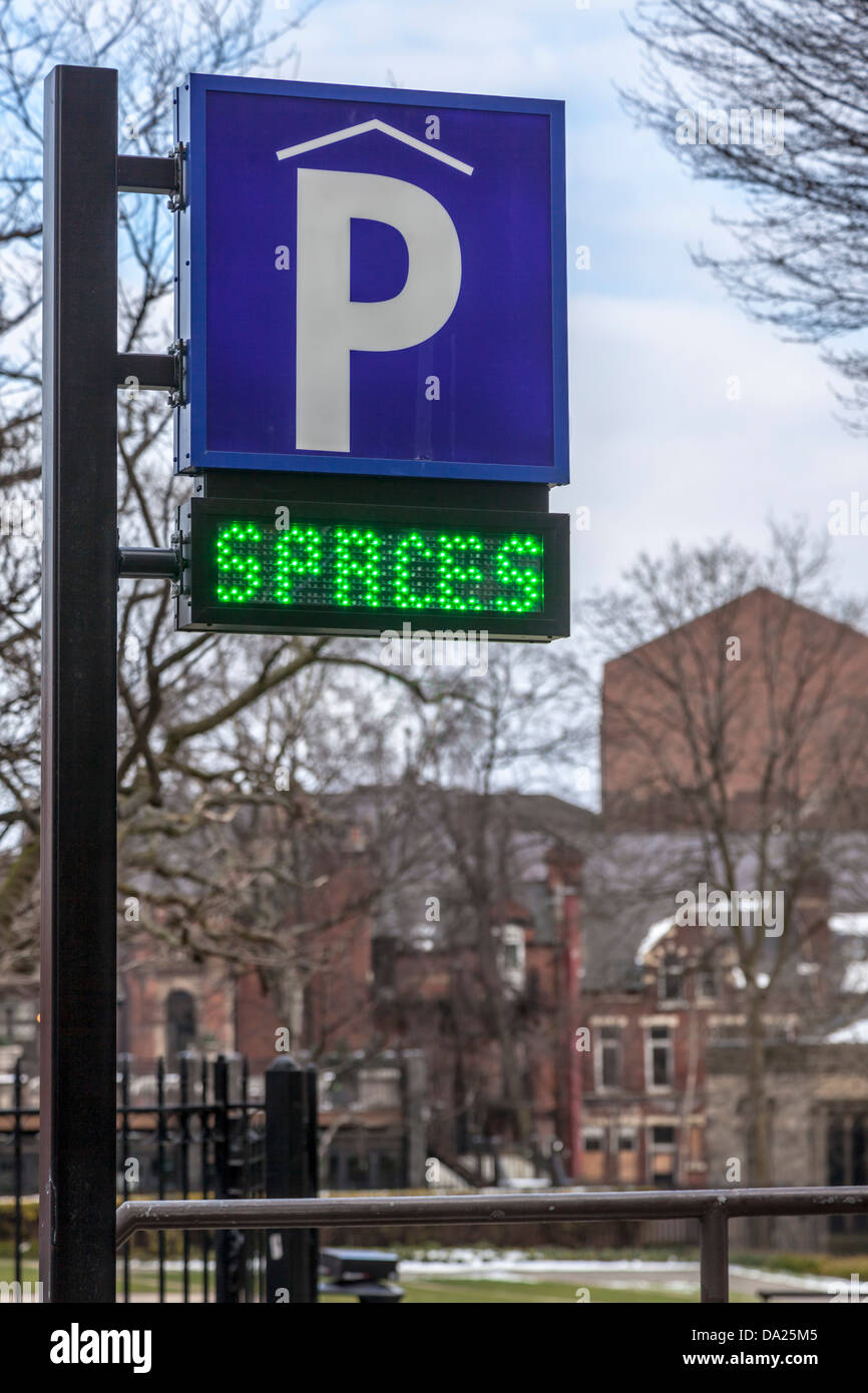 Car Parking sign with green LED sign showing the word 'spaces'. Blurred ...