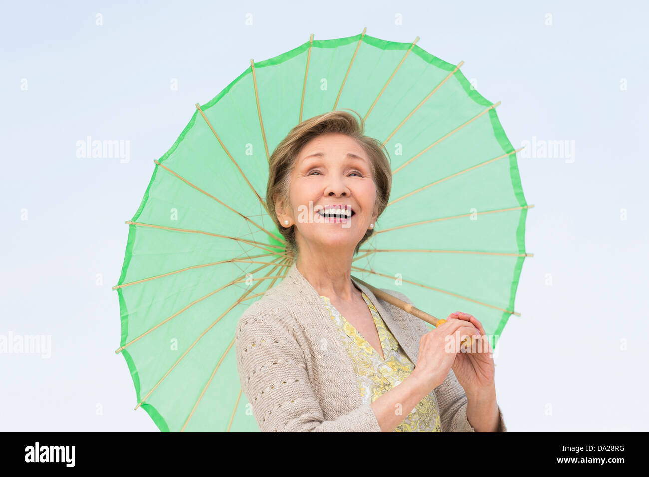 Portrait of senior woman holding green parasol Stock Photo - Alamy