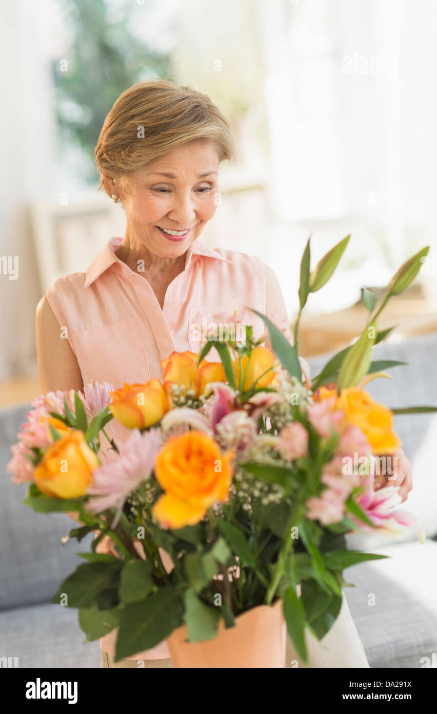 Senior woman arranging flowers at home Stock Photo - Alamy