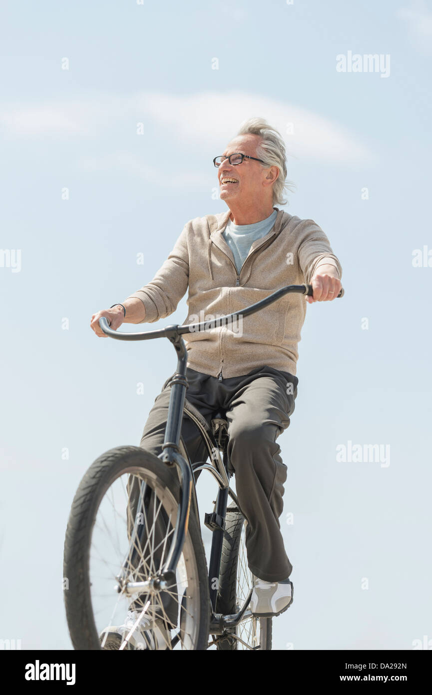 Senior man riding bicycle Stock Photo - Alamy