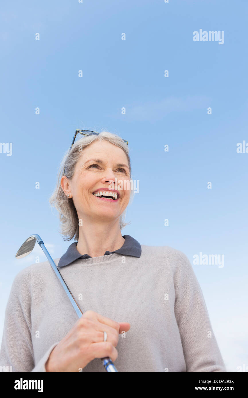 Senior woman holding golf club Stock Photo - Alamy