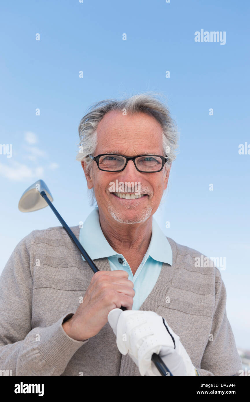Senior man holding golf club Stock Photo - Alamy