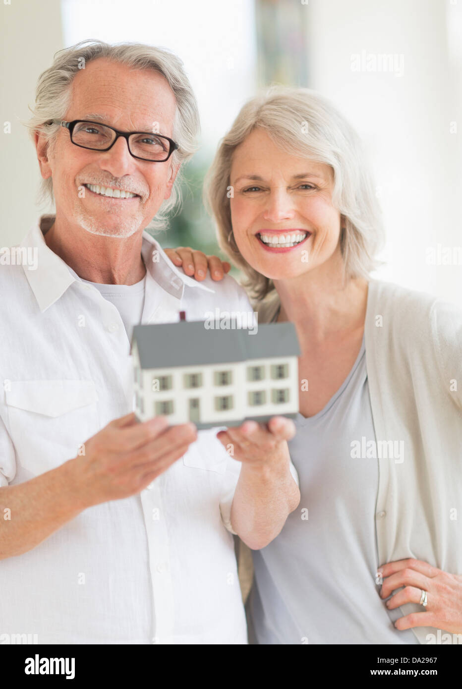 Senior couple holding model house Stock Photo - Alamy