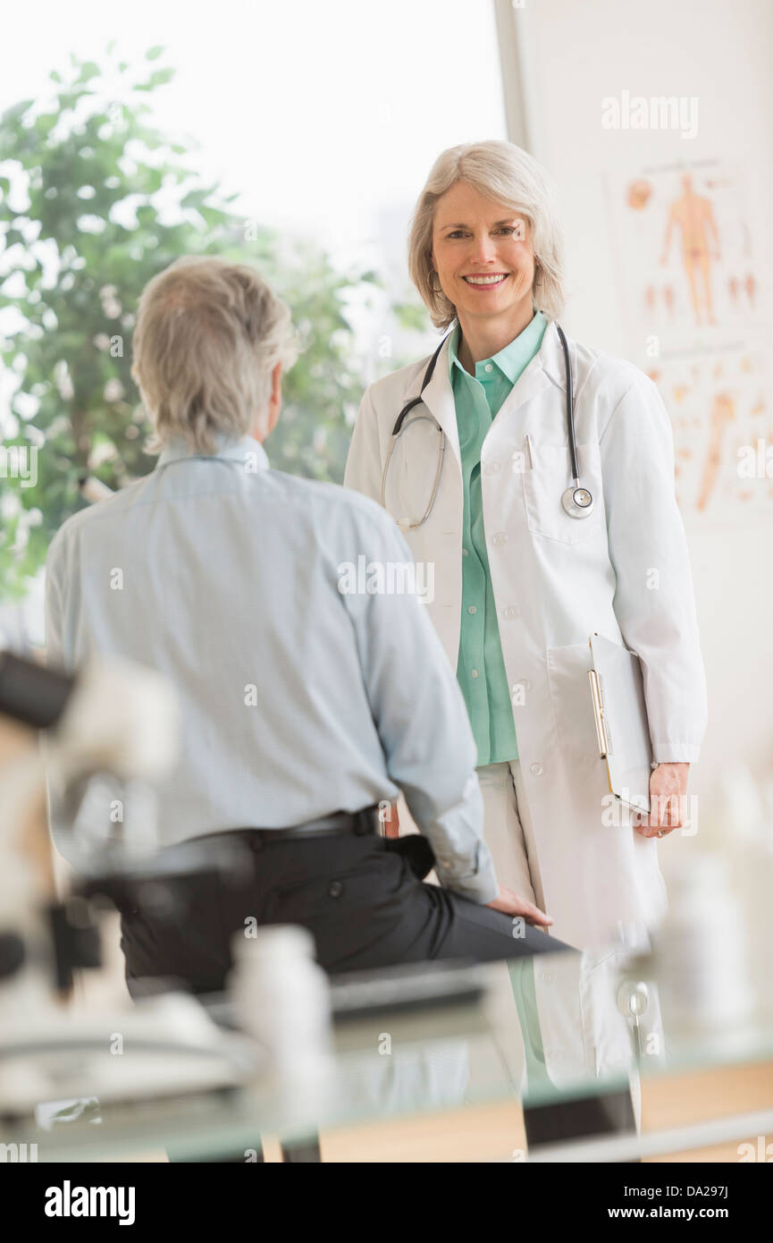 Female doctor talking to male patient in her office Stock Photo - Alamy