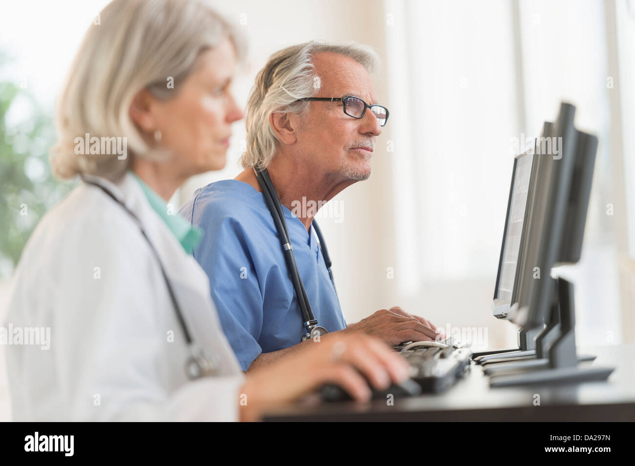 Female and male doctors working at computers Stock Photo - Alamy