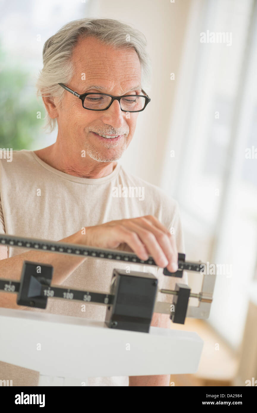 Senior man on weight scale Stock Photo - Alamy