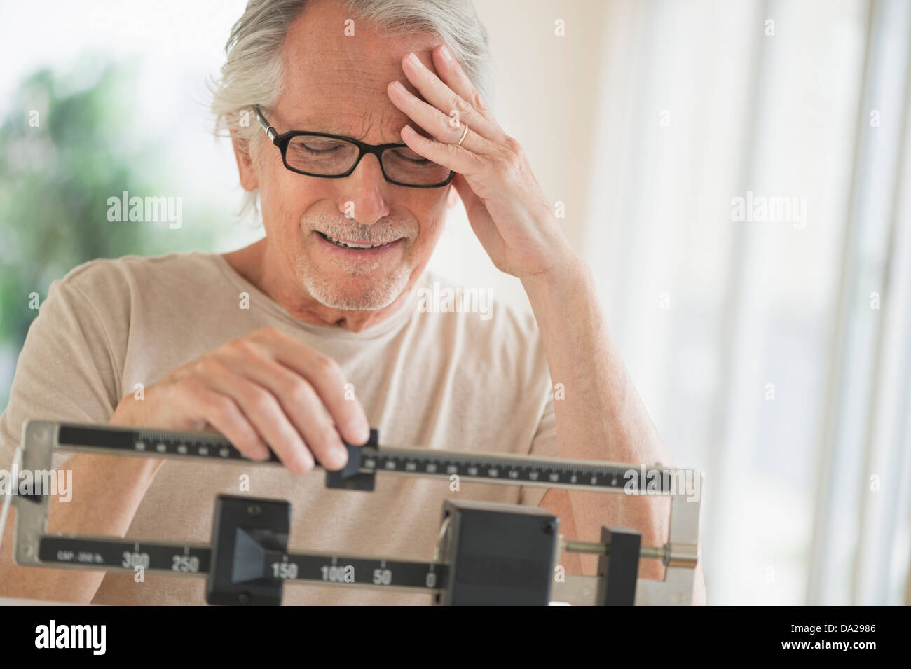 Senior man on weight scale Stock Photo - Alamy