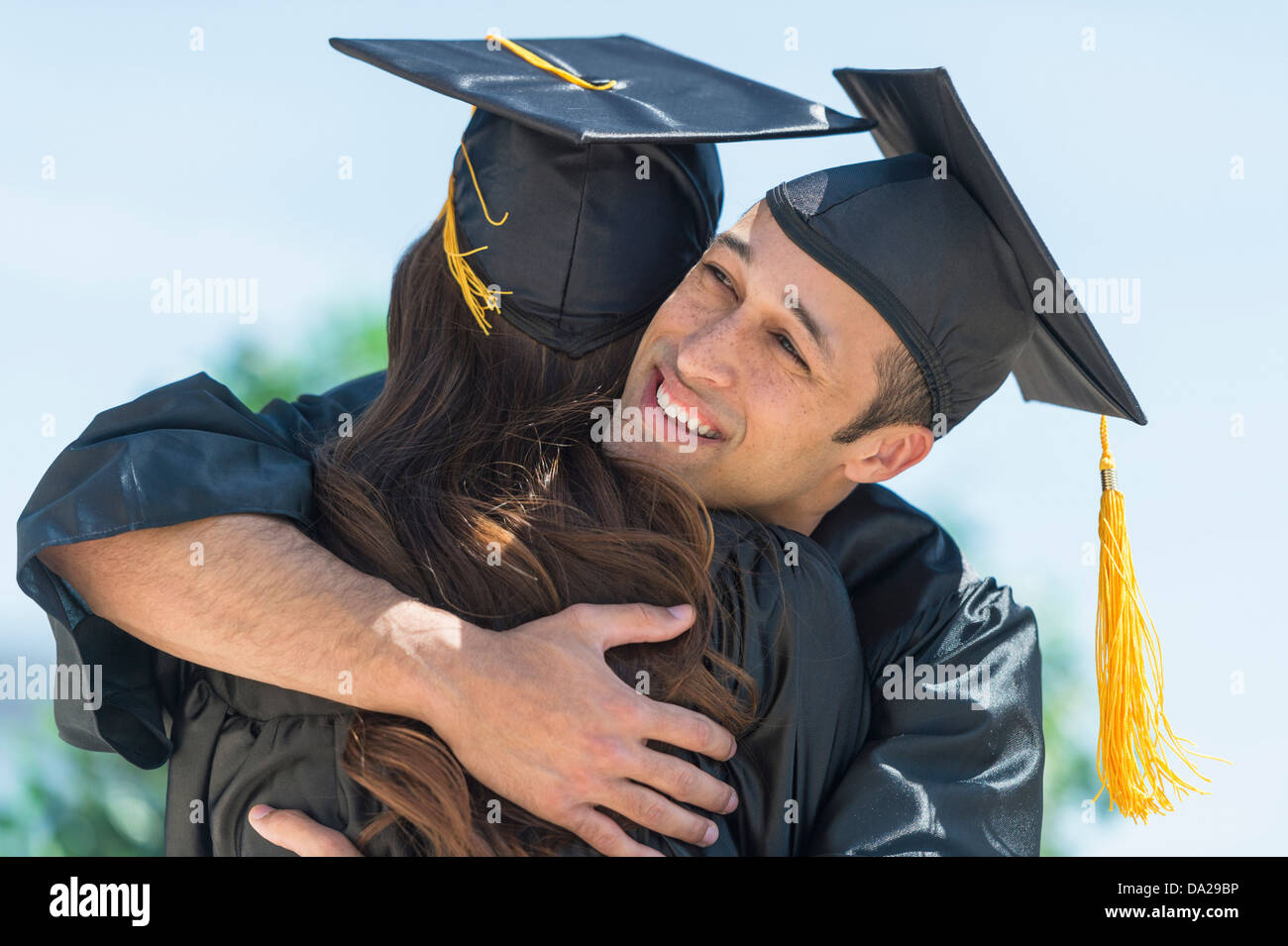 Male and female students embracing on graduation ceremony Stock Photo ...