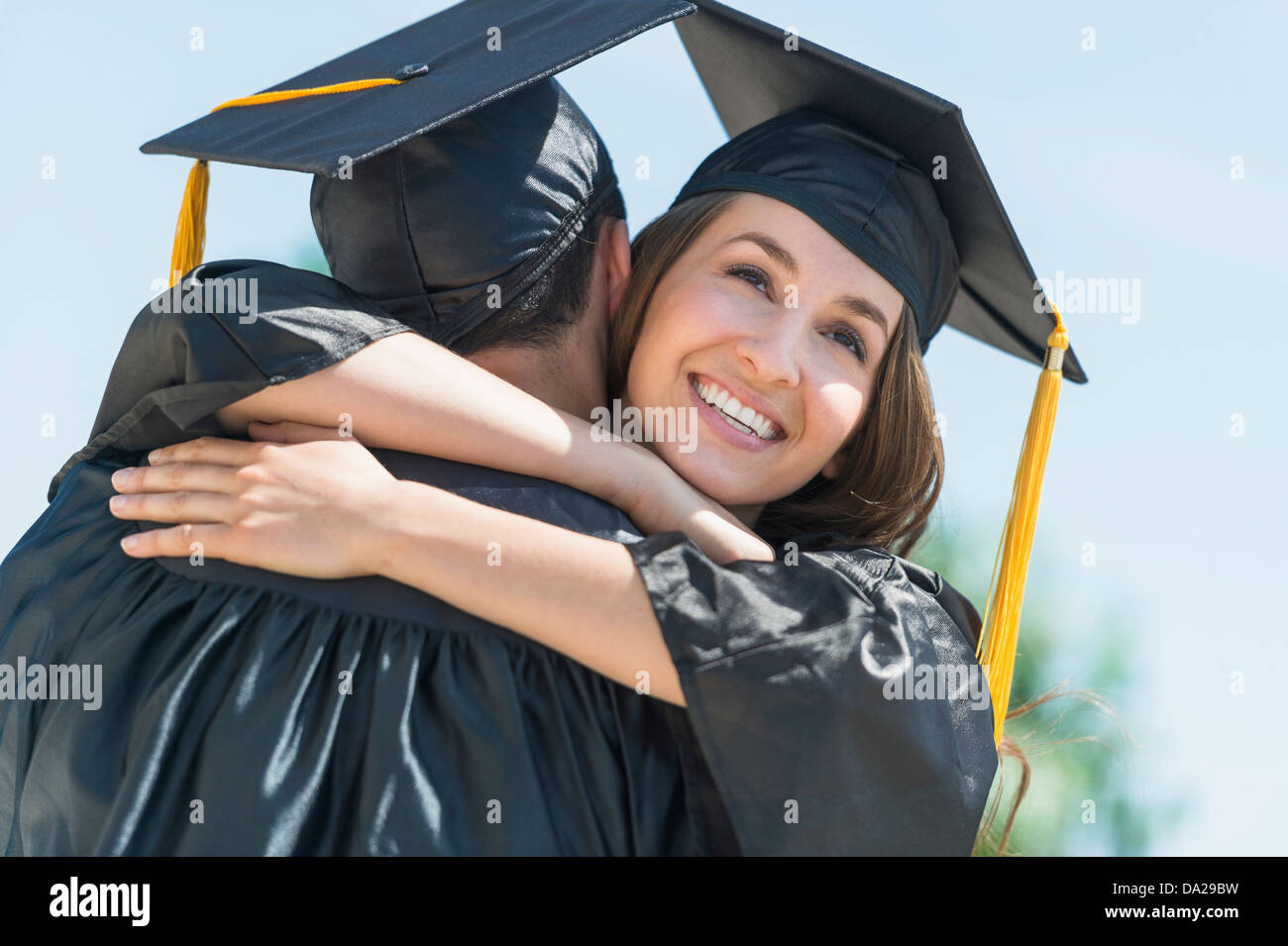 Female and male students embracing on graduation ceremony Stock Photo ...