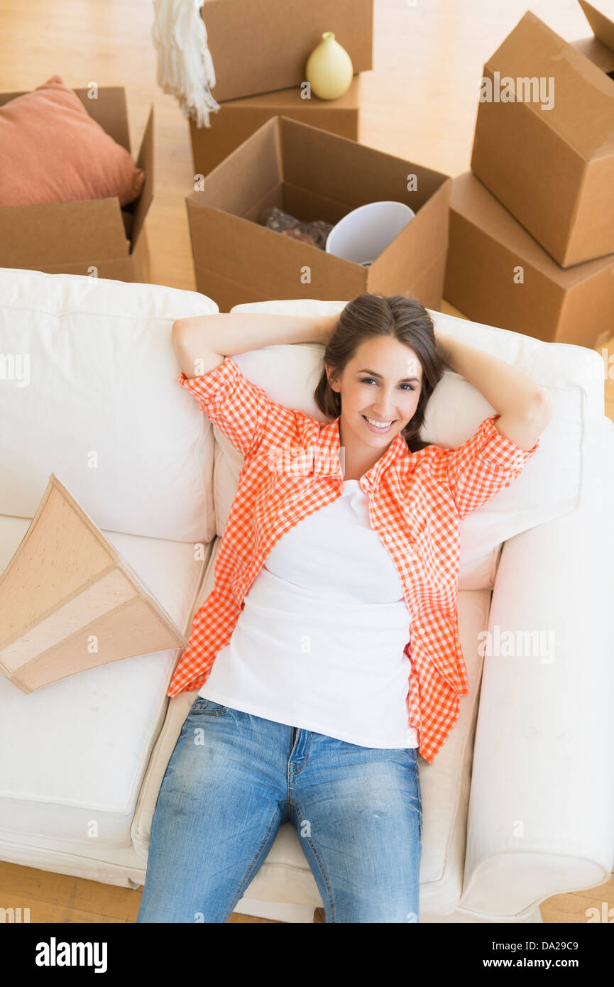 Young woman resting on sofa after moving into new home Stock Photo - Alamy