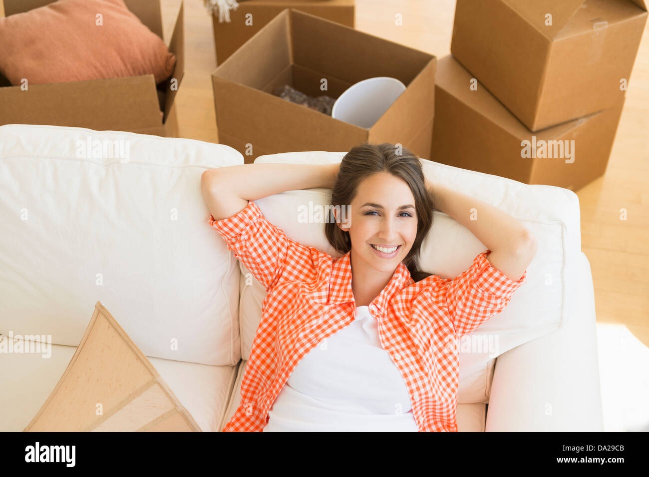 Young woman resting on sofa after moving into new home Stock Photo - Alamy