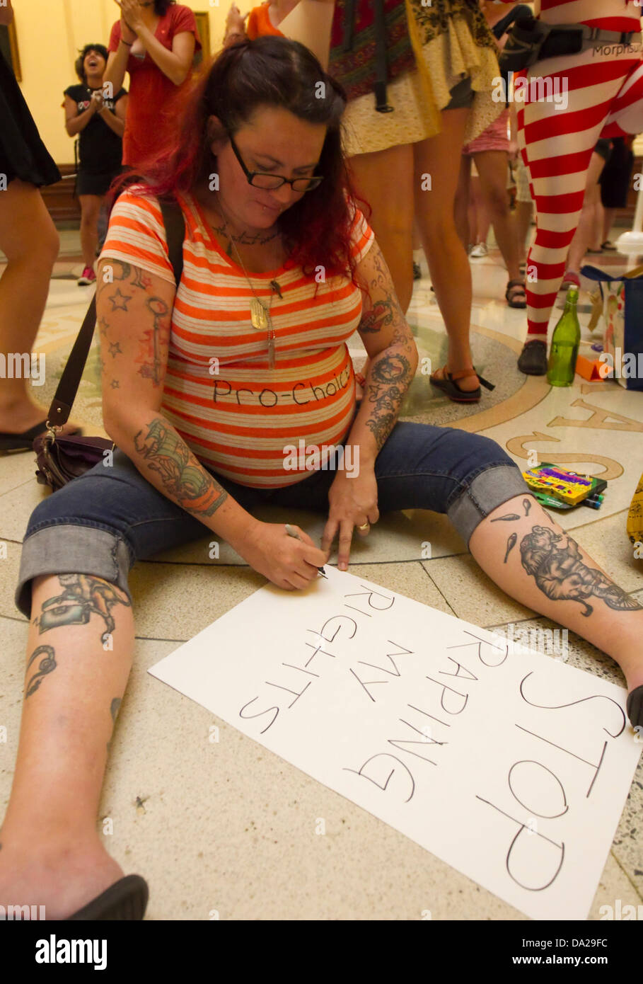 A pro-choice supporter makes a protest sign as hundreds of pro-life and ...