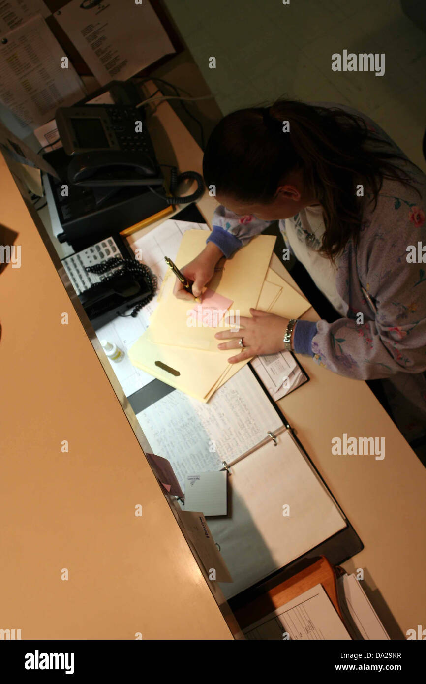 female woman nurse desk paperwork work working write writing medical ...