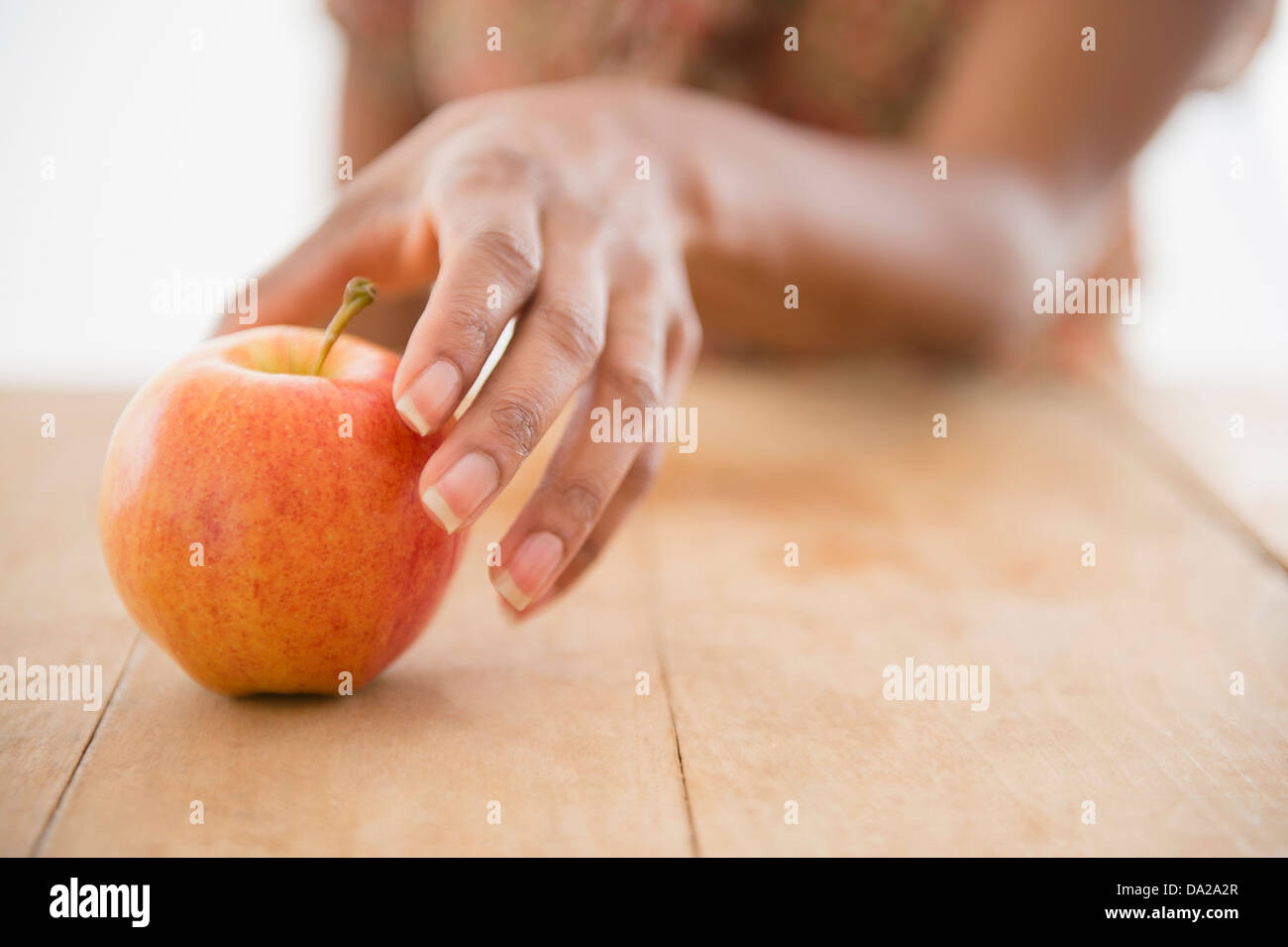 Woman's hand reaching for apple Stock Photo - Alamy