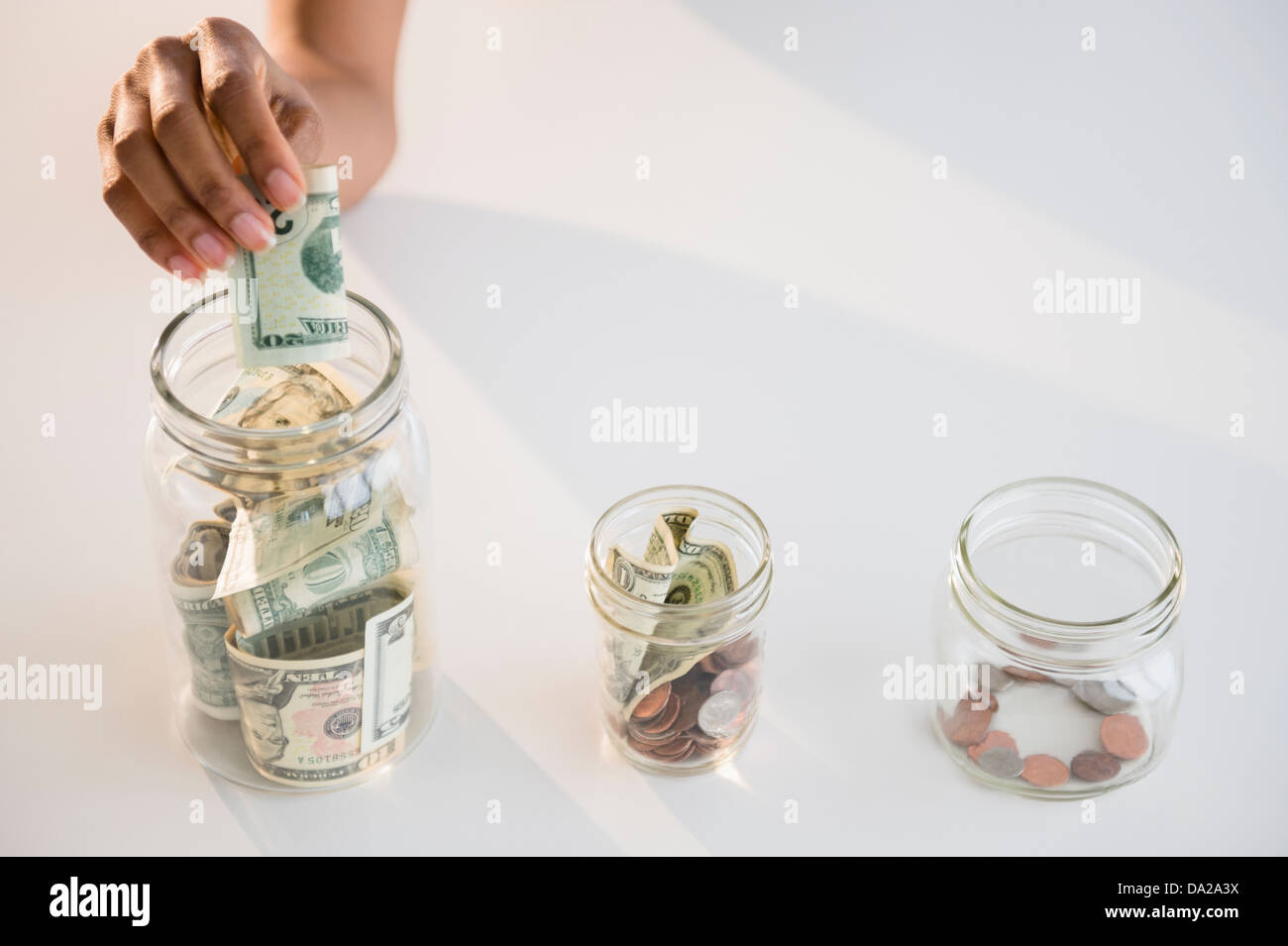 Savings jar money hand hi-res stock photography and images - Alamy