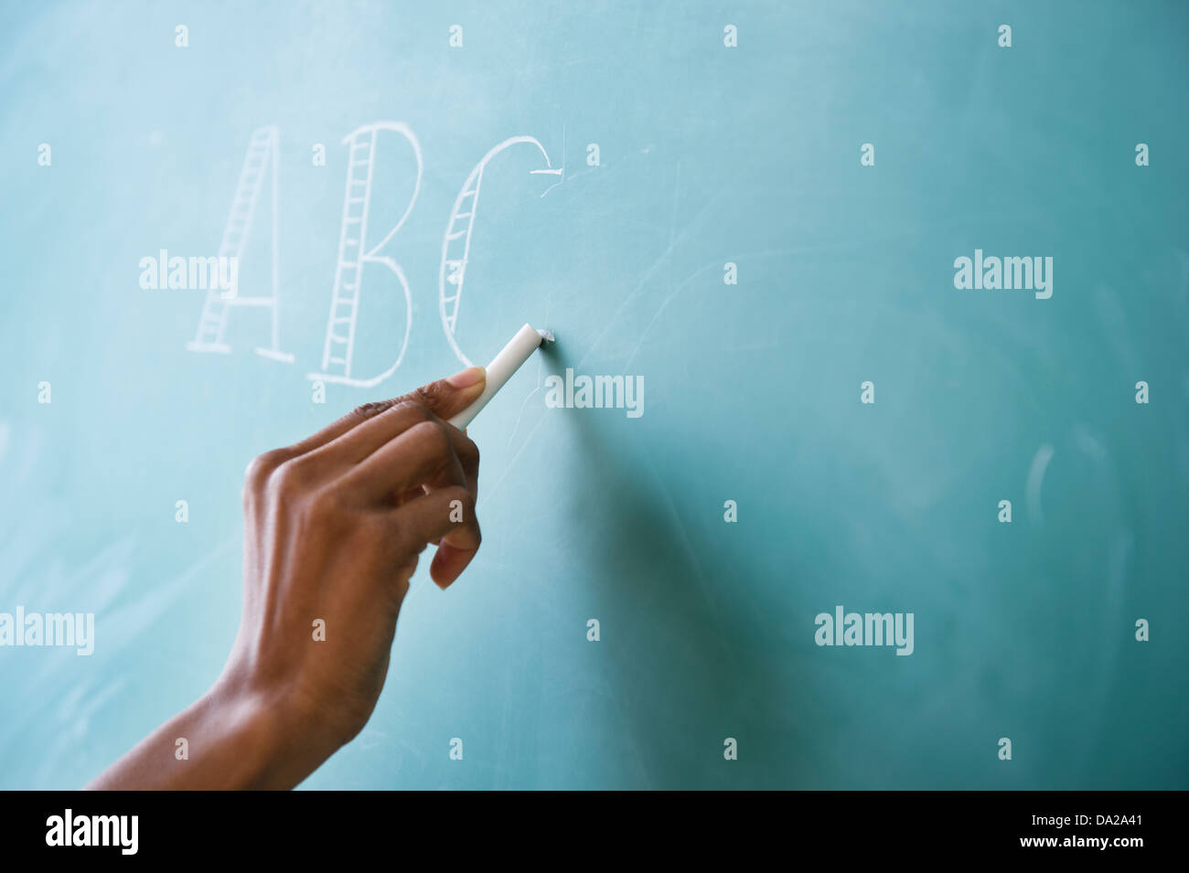 Close up of woman's hand writing alphabet on blackboard Stock Photo - Alamy