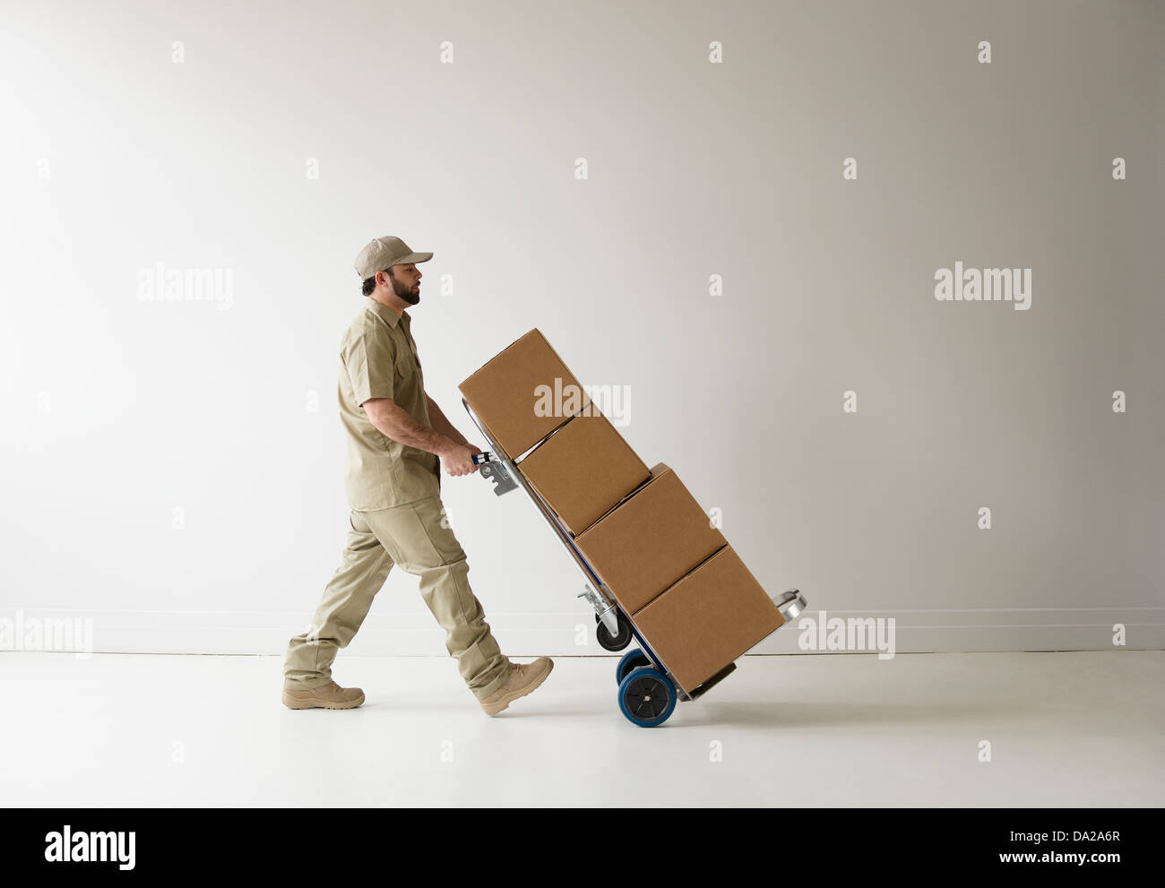 Delivery man walking with push cart Stock Photo - Alamy