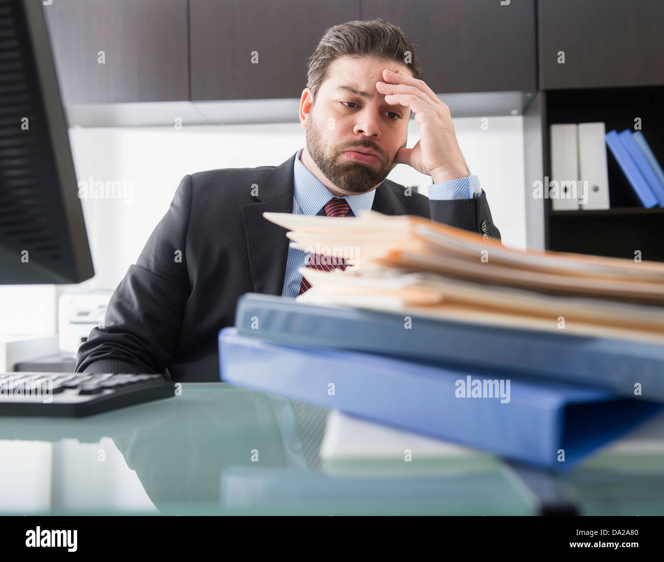 Portrait of tired businessman sitting in office Stock Photo - Alamy