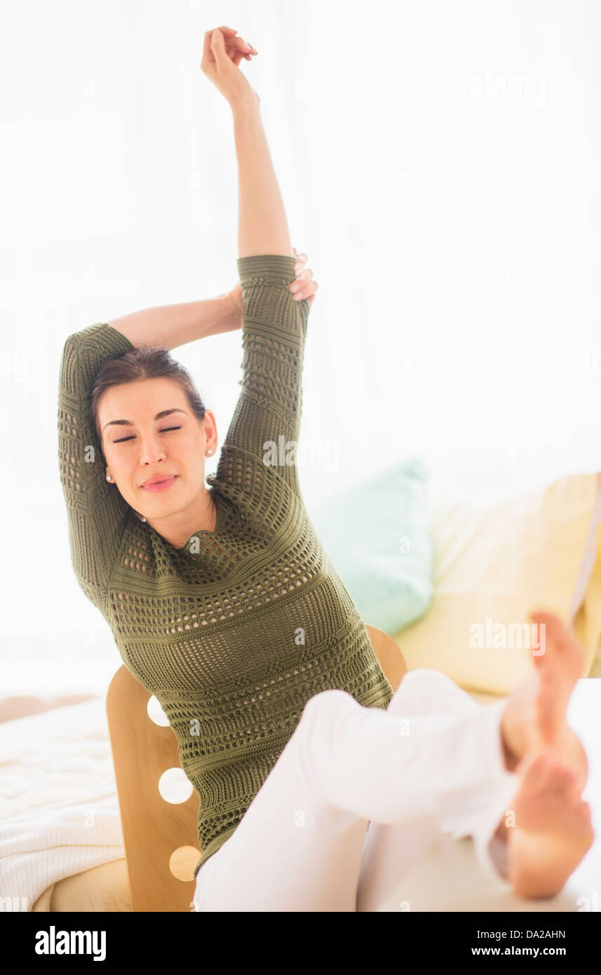 Woman with feet up and raised arms Stock Photo - Alamy