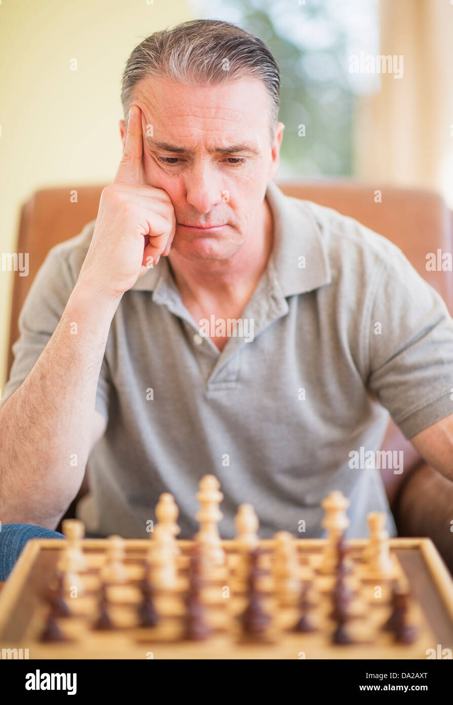 Portrait of man concentrating during chess game Stock Photo - Alamy