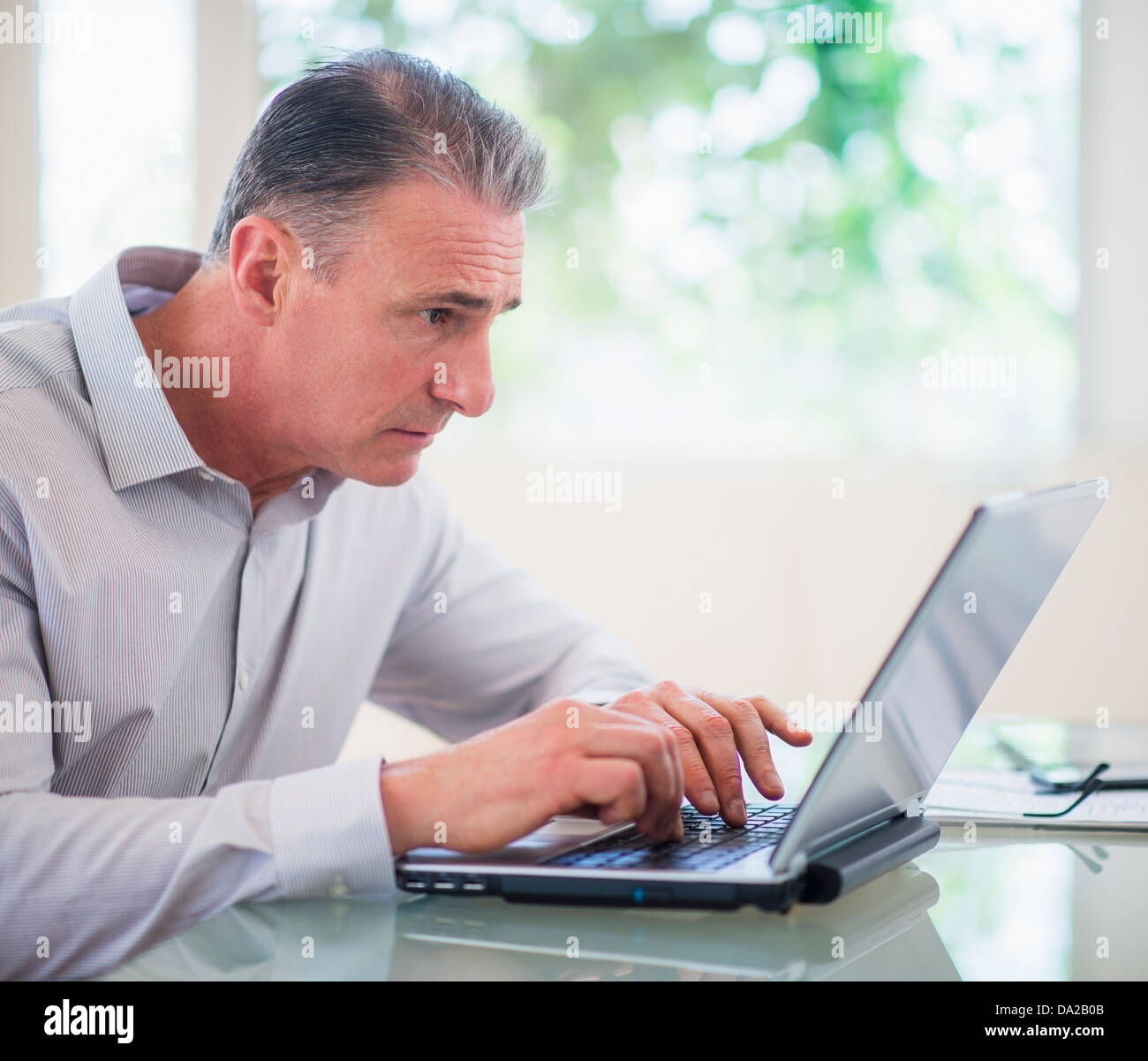 Portrait of tired man working on laptop Stock Photo - Alamy