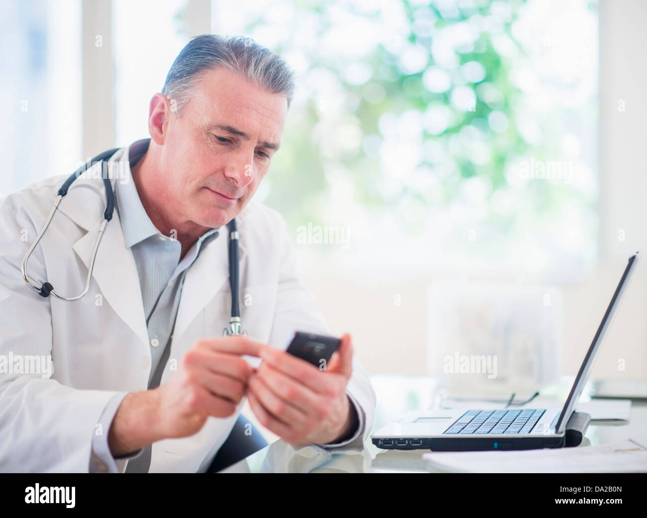 Portrait of doctor using mobile phone Stock Photo - Alamy