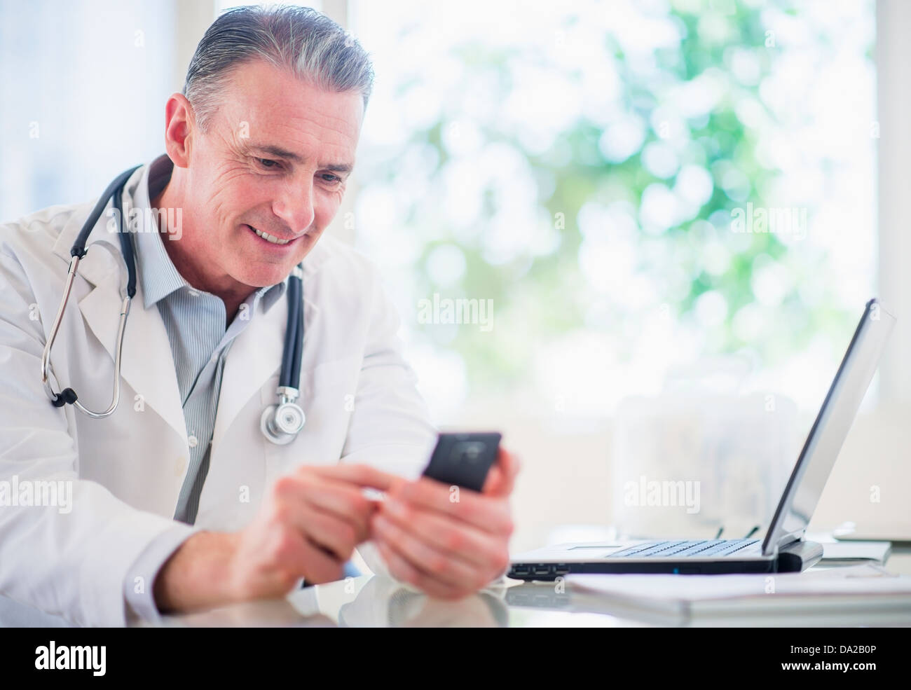 Portrait of doctor using mobile phone Stock Photo - Alamy