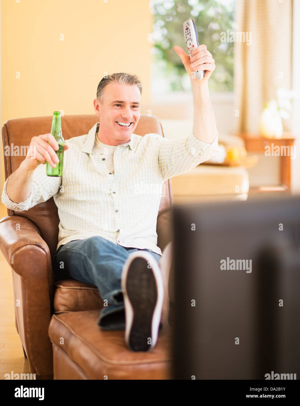 Portrait of cheerful man watching tv Stock Photo - Alamy