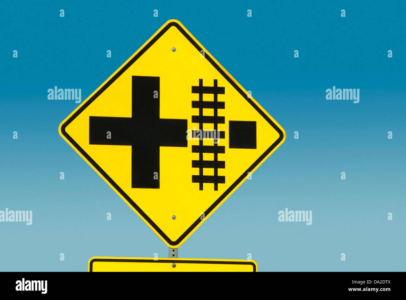 Yellow road sign depicting railroad crossing Stock Photo - Alamy