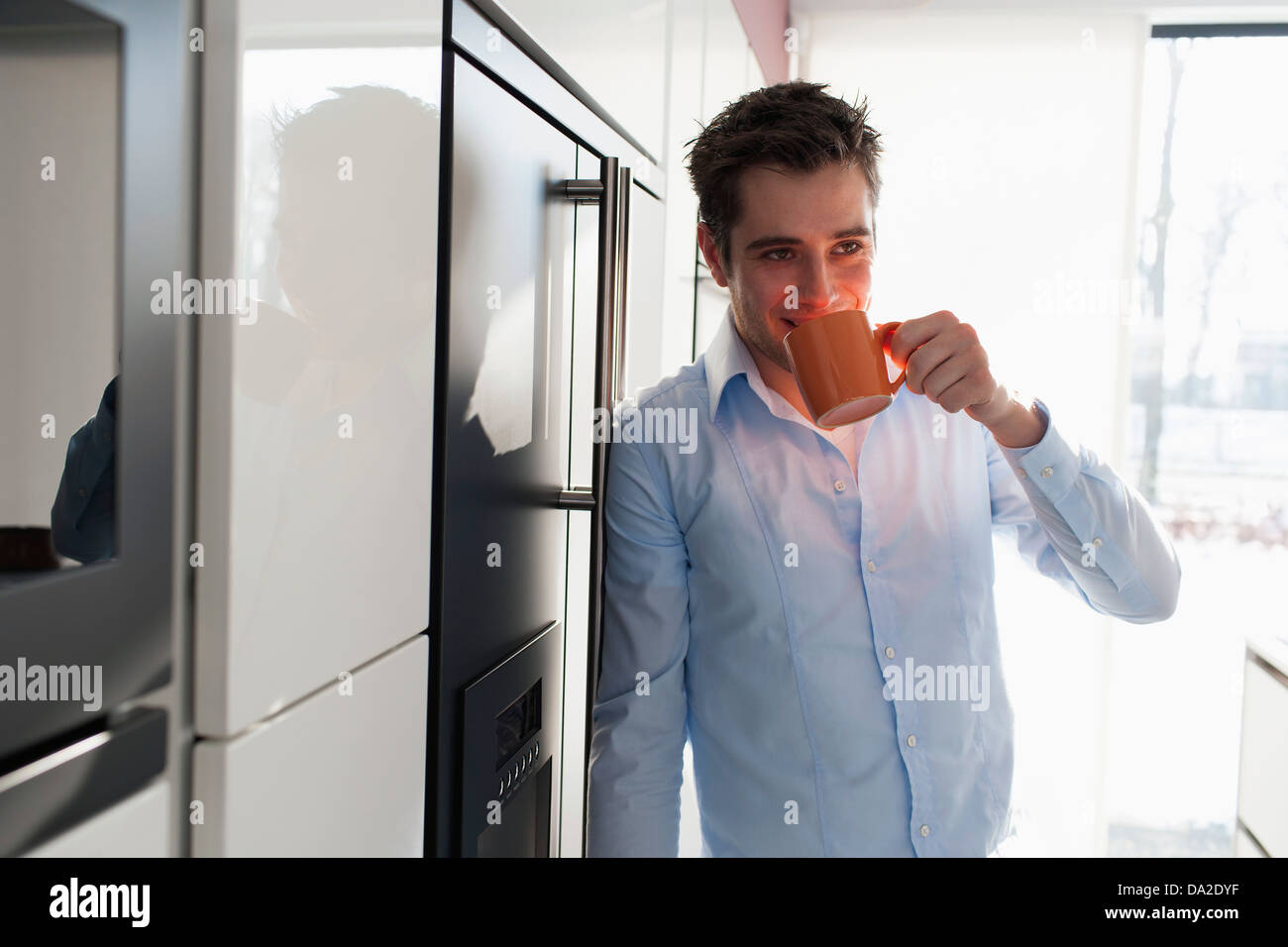 Man drinking coffee in kitchen Stock Photo - Alamy