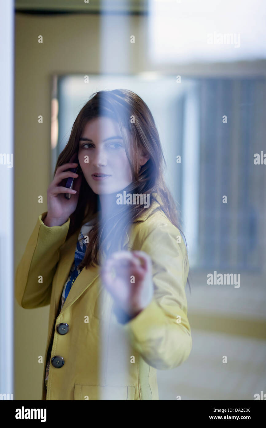 Woman standing behind door hi-res stock photography and images - Alamy