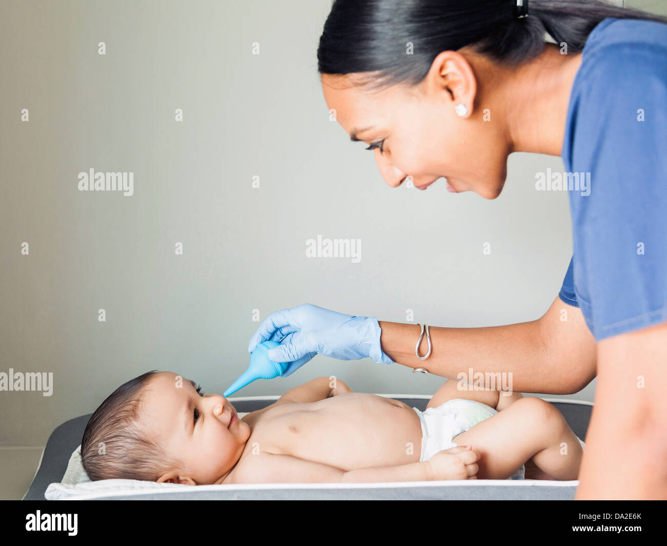 Nurse cleaning baby boy's (2-5 months) nose Stock Photo - Alamy