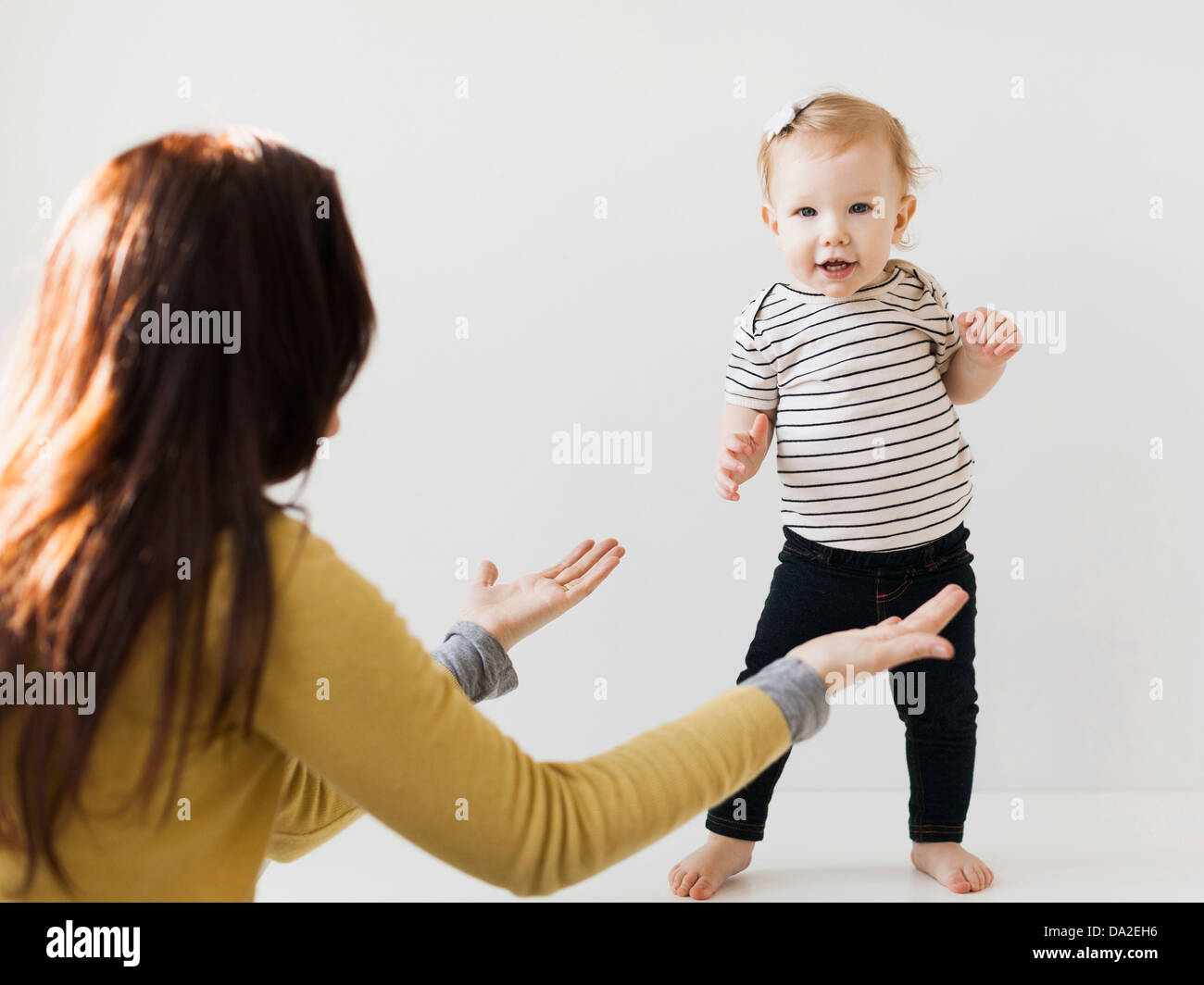 Mother raising hands towards her daughter (12-17 months Stock Photo - Alamy