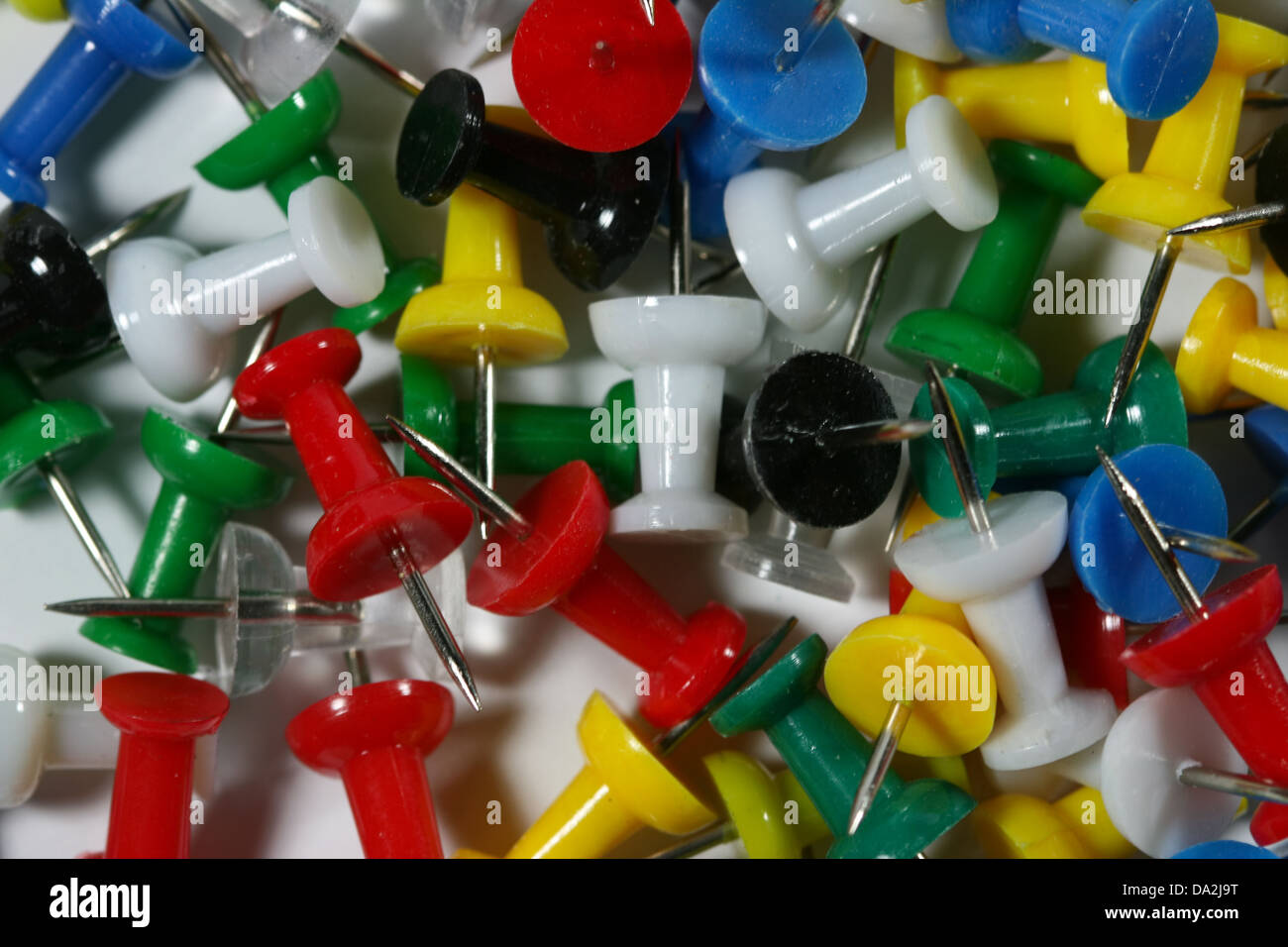Bundle of push pins in different color, on white background, closeup ...